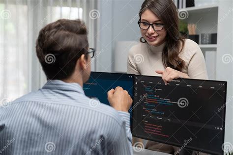 Woman Standing Opposite To Man Programmer Working On Desk To Discuss