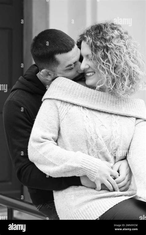Couple Hugging And Kissing Smiling Sitting On Handrails Of Church Stock