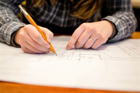 Close Up Of Female Architect Drafting Plans On Blueprint Paper Stock