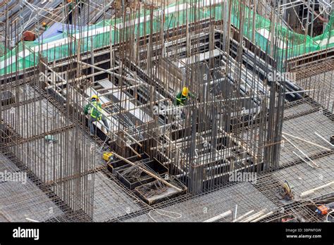 Construction Workers Wearing Safety Vests And Helmets Working On A