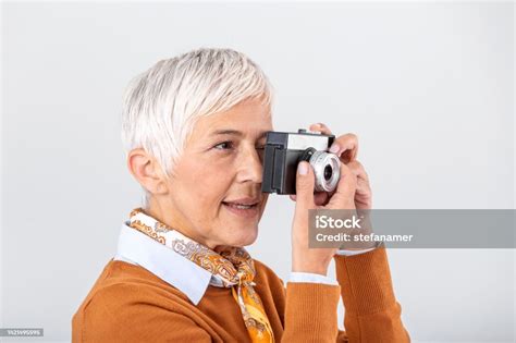 성숙한 여성 사진 작가 오래 된 복고풍 카메라와 함께 사진을 찍고 전문 사진 작가가 사진 촬영을하고 있습니다 사진작가에 대한 스톡 사진 및 기타 이미지 Istock