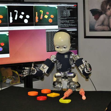 the icub robot looking at a table full of objects in the back screen