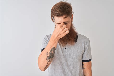 고립 된 흰색 배경 에 서 회색 폴로를 입고 젊은 빨간 머리 아이리쉬 남자 피곤 코와 눈을 느끼는 피로와 두통을 느끼고 스트레스와 좌절 개념 건강한 생활방식에 대한 스톡