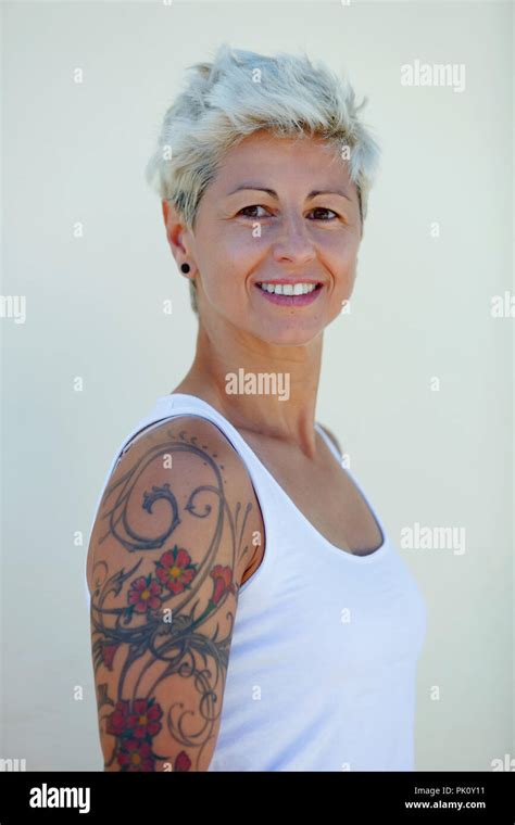 Blonde Woman With Flowered Tattoos On Her Arm Stock Photo Alamy