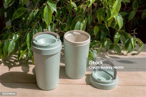 녹색 단풍의 배경에 나무 책상에 커피 차 및 기타 뜨겁고 차가운 음료를위한 플라스틱 재사용 가능한 열성 컵 레이블의 공간을 복사합니다 0명에 대한 스톡 사진 및 기타 이미지