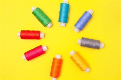 Premium Photo Multi Colored Thread Spools On Yellow Background
