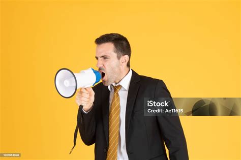 흰색 정장과 넥타이를 입고 메가폰을 쓰고 노란 배경으로 비명을 지르는 잘생긴 사업가의 초상화 개념에 대한 스톡 사진 및 기타 이미지 Istock
