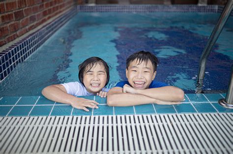 Asian Chinese Young Sibling Enjoy Having Fun At Swimming Pool During