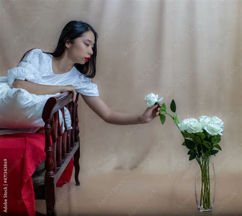 Bella Chica Asi Tica Sentada En Cama Coge Una Rosa Blanca De Un Jarr N En El Suelo Stock Photo