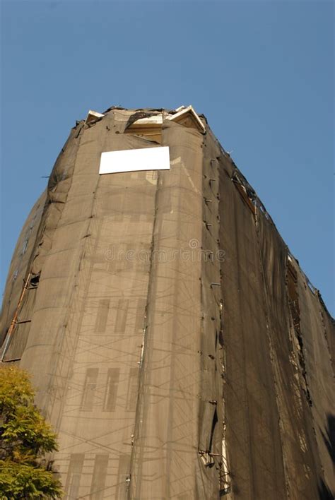 Building Under Construction With Protective Scaffolding With Fabric