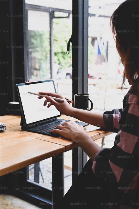 디지털 태블릿에 스타일러스 펜 쓰기를 들고 있는 여성 그래픽 디자이너의 측면 모습 사진 Unsplash의 테이블 이미지
