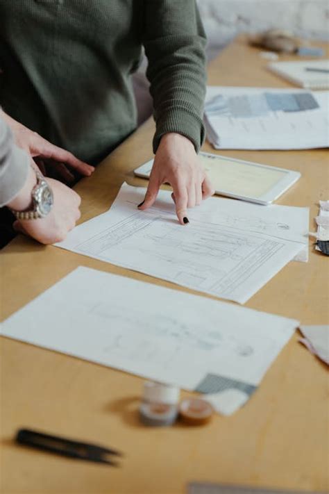 디자이너 샘플 서 있는 손 아이패드 아틀리에 양장점 워크숍 의류 디자이너 익명의 일하는 재단사 재봉 공장 직업 직장 카탈로그 테이블에 관한 무료