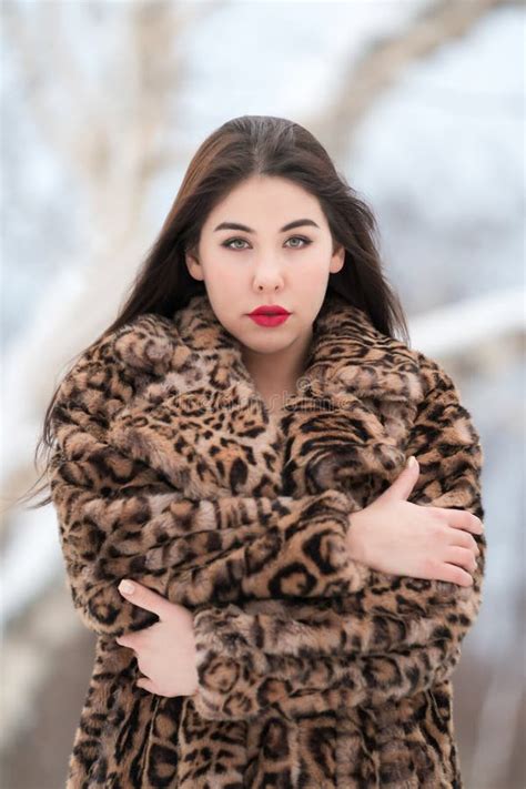 Portrait Young Woman With Long Hair Dressed In Faux Fur Coat With Leopard Pattern Looking At