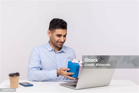 명랑한 남자 선물 상자를 들고 노트북 화면을보고 온라인 통신을하면서 생일 선물을 주는 직원에 대한 스톡 사진 및 기타 이미지 직원 선물 인도 문화 Istock