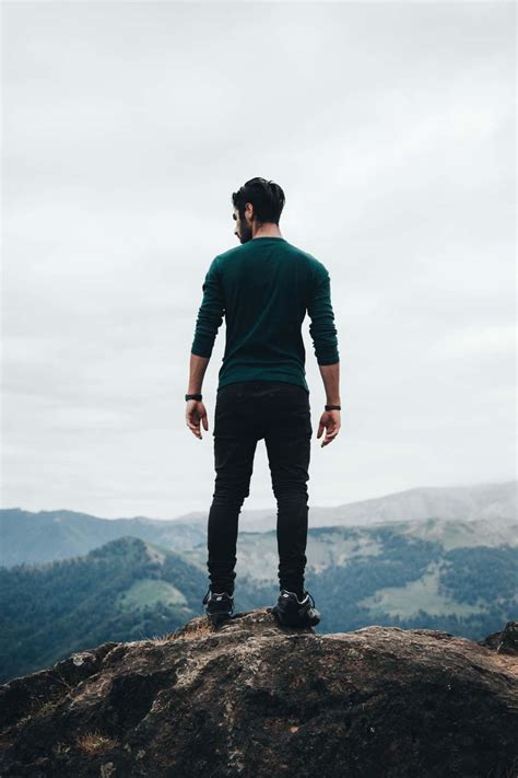 Download Man Standing On Top Of A Mountain