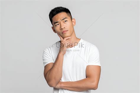 한 손으로 턱을 잡는 흰색 티셔츠를 입는 남자