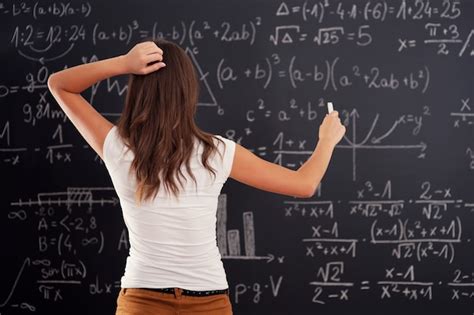 Young Woman Looking At Math Problem On Blackboard Free Photo