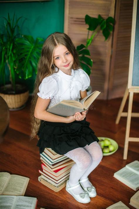 Una Colegiala Con El Pelo Largo Rojo En Un Uniforme Escolar Coloca Al Consejo Escolar Cercano
