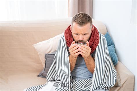 뜨거운 치유 차를 마시는 발열을 가진 아픈 사람 고온 개념 남자는 심하게 아프다 발열을 내리는 방법 감기 증상 및 원인 독감에 걸린 아픈 사람 감기와 독감에 대한 스톡 사진