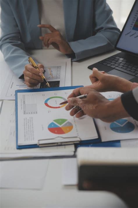 Close Up Of Business Team Analyzing Income Charts And Graphs With Modern Laptop Computer
