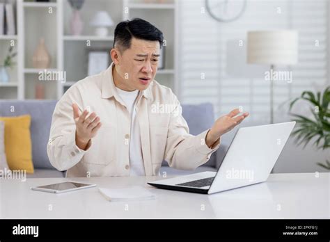 Angry Man At Home Working With Laptop Frustrated Asian Man Looking At