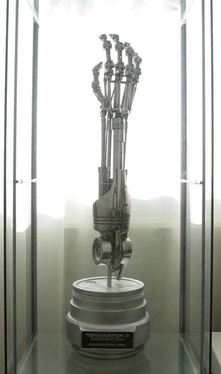 A Silver Sculpture In A Glass Case With The Light Coming Through Its