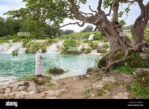 Arab Man On Holiday Viewing A Waterfall At Darbat Park In Salalah Oman