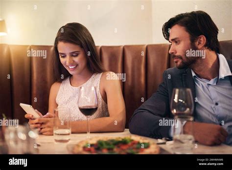 I Wonder Who Shes Chatting Toa Young Woman Checking Her Phone While On A Dinner Date With Her