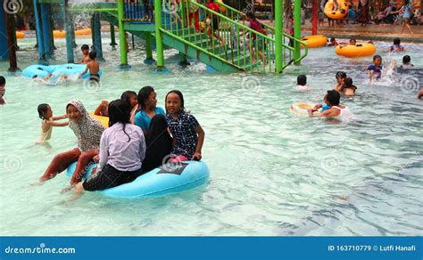 Visitors Of The Amusement Park Play While Enjoying The Pool Of Water