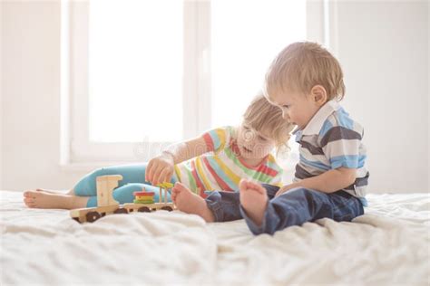 Hermano Y Hermana Jugando En La Cama Del Dormitorio Imagen De Archivo