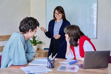 Premium Photo Middle Aged Female Teacher Giving Lesson To Teenage