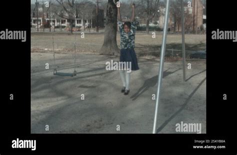 1960s Girl Swings On Monkey Bars On School Playground Stock Video