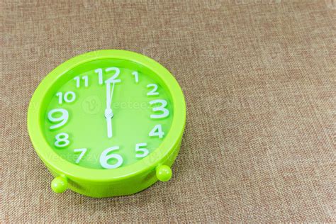 Green Alarm Clock On Brown Sackcloth Background Show Six Oclock Or 6