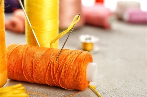Premium Photo Spool Of Sewing Thread With Needle On Table