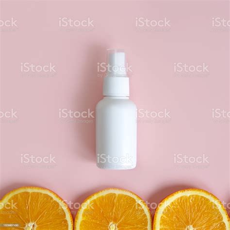 브랜드가 없는 흰색 플라스틱 스프레이 병과 분홍색 배경의 주황색 슬라이스 테두리 모형 스킨케어 미용 및 액상 항균 스프레이 컨셉 0명에 대한 스톡 사진 및 기타 이미지