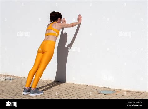 Sporty Woman Doing Push Off Exercises Against A Wall Stock Photo Alamy