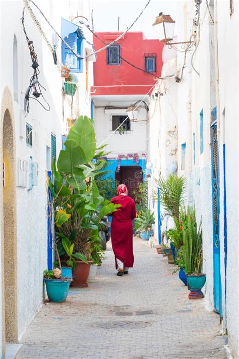 Woman Wearing Traditional Moroccan Djellaba Walking In Narrow Street Of