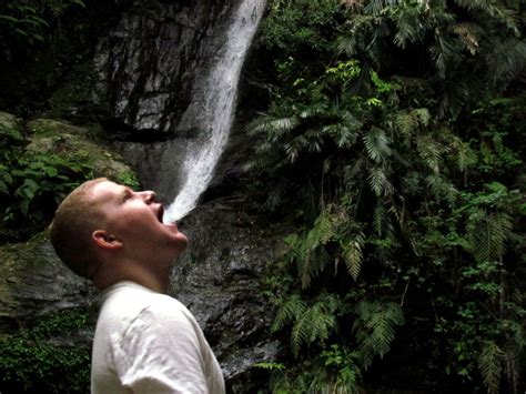 A Man Standing In Front Of A Waterfall With His Mouth Open And Eyes