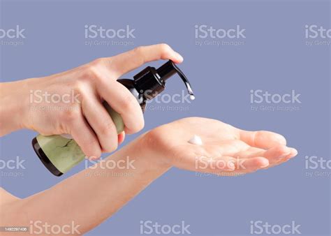 모이스처라이저 스킨케어 그리고 스튜디오의 파란색 배경에 분리된 크림 한 병을 들고 있는 손 미용 화장품 및 수분 치료 및 손질을 위해 손바닥에 로션이나 자외선 차단제를