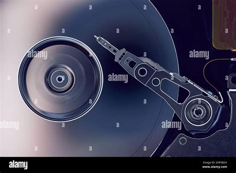 spinning hard drive disks and writing head macro photo illuminated from