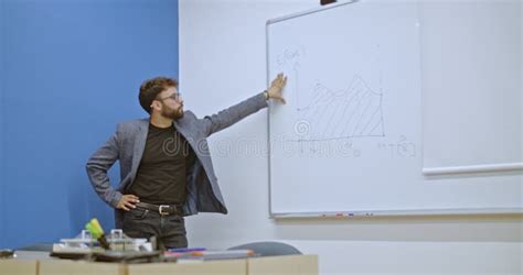 Professor Explaining A Graph To Students During A Business Class At The