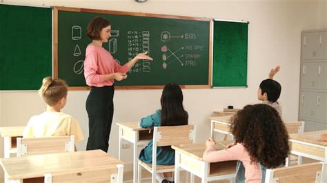 Premium Photo Teacher Checking Cute Student Homework While Explaining
