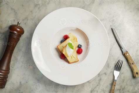 Baba Au Rhum With Raspberry Blueberry Cream And Bread Served In Dish Isolated On Marble