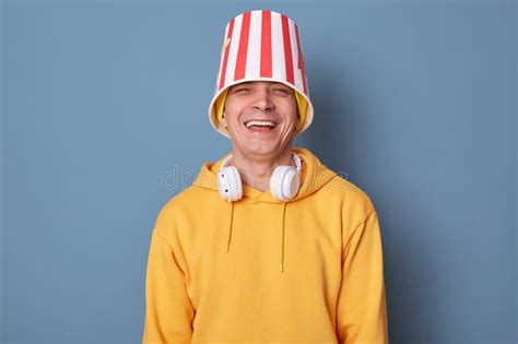 Portrait Of Happy Overjoyed Man Wearing Beanie Hat And Casual Yellow