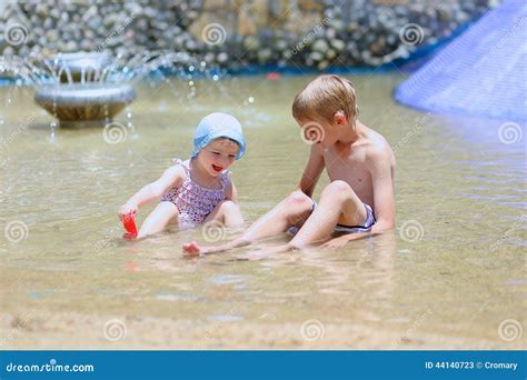 Brother And Sister Playing In Outdoors Swimming Pool Stock Image
