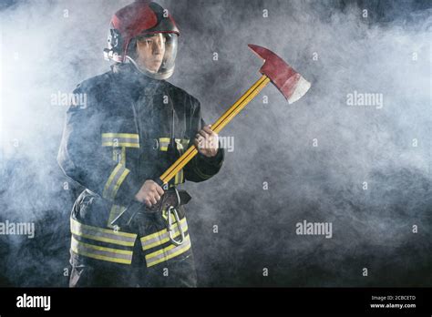 Young Adult Firefighter Saving People From Fire Wearing Uniform And