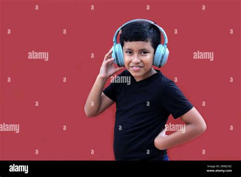 9 Year Old Dark Skinned Latino Boy Listens To His Headphones And Enjoys