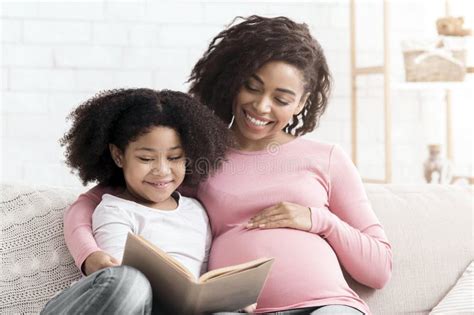 Pregnant Afro Woman and Her Preschool Daughter Reading Book Together Stock Photo - Image of cute ...