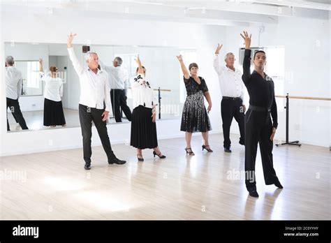 Mixed Race Dance Teacher Demonstrating To His Ballroom Dancing Class