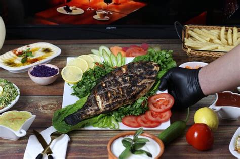Premium Photo Serving Grilled Fish Dish With Garnishes Dips Sauces